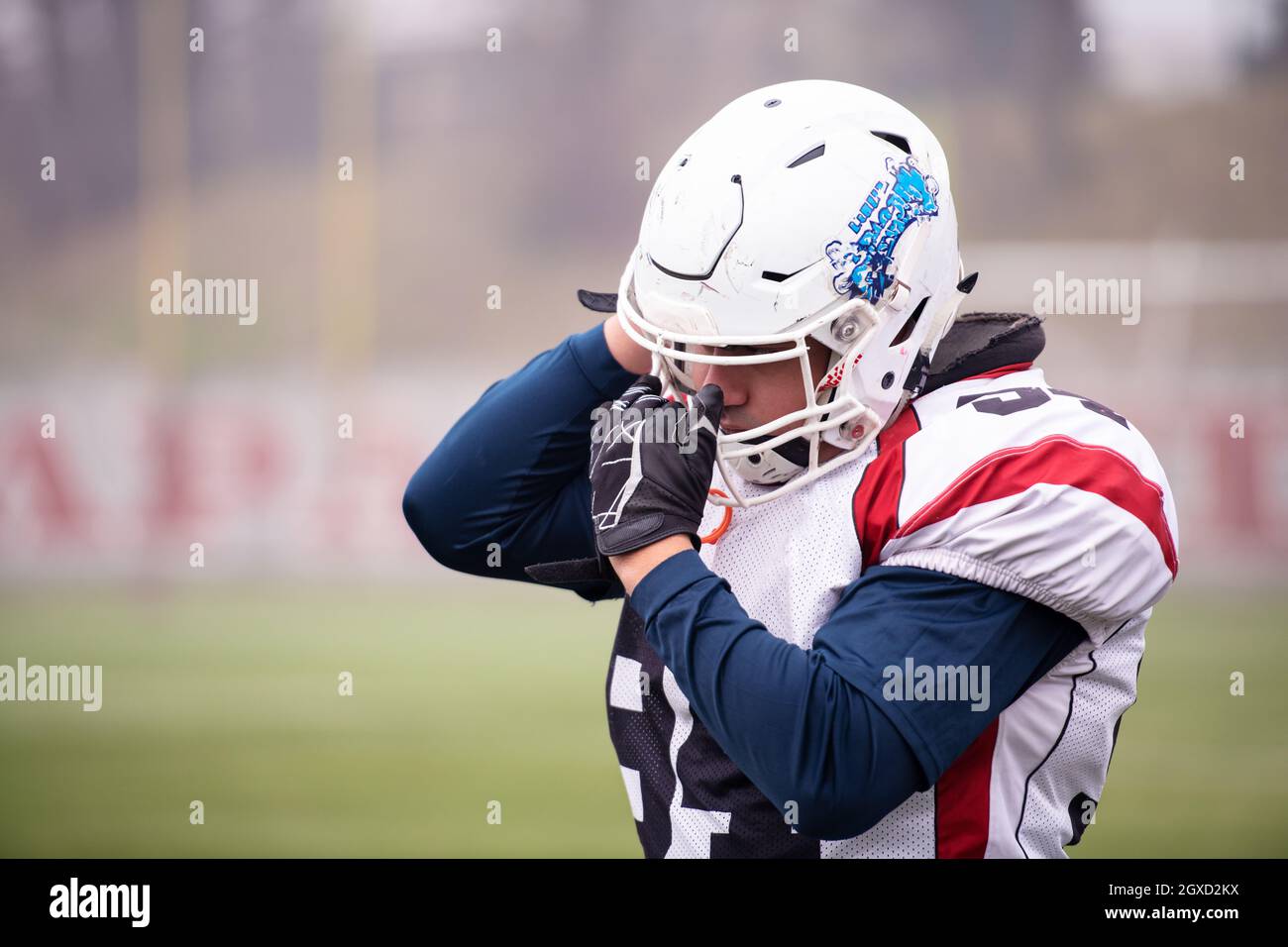 portrait of young confident American football player standing on the ...