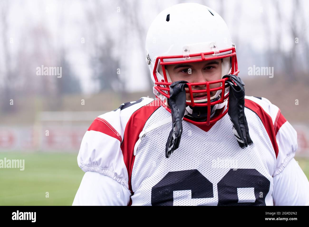 portrait of young confident American football player standing on the ...