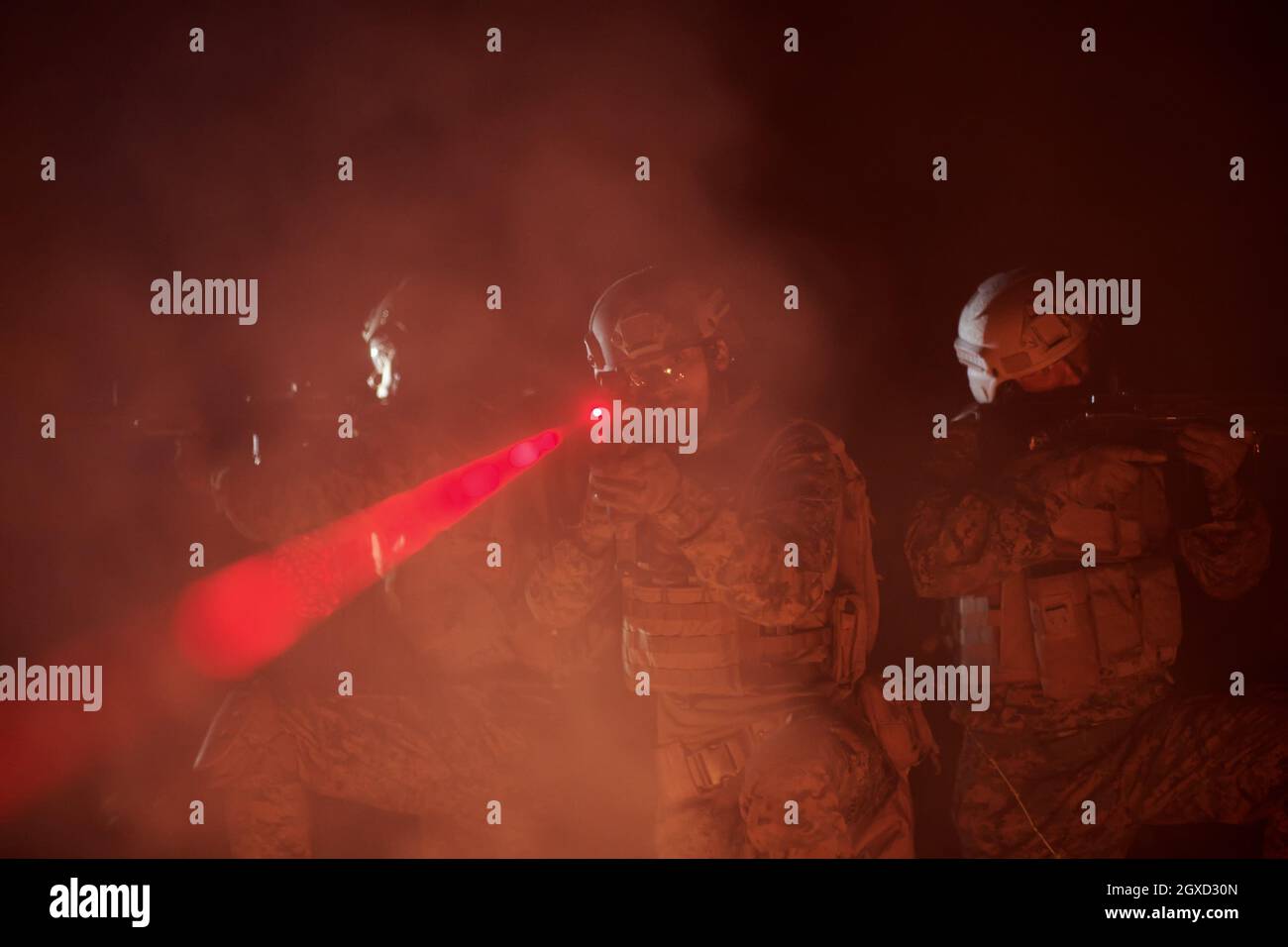 soldiers squad in action on night mission using laser sight beam lights ...
