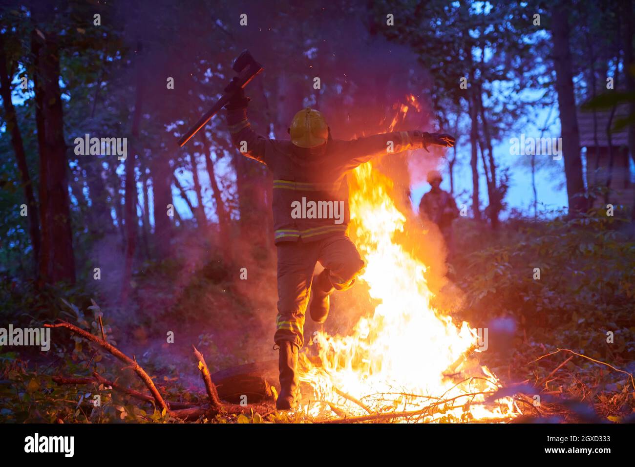 firefighter hero in action danger jumping over fire flame to rescue and ...