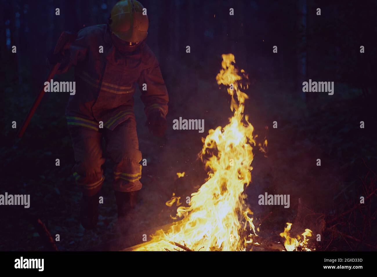 firefighter hero in action danger jumping over fire flame to rescue and ...