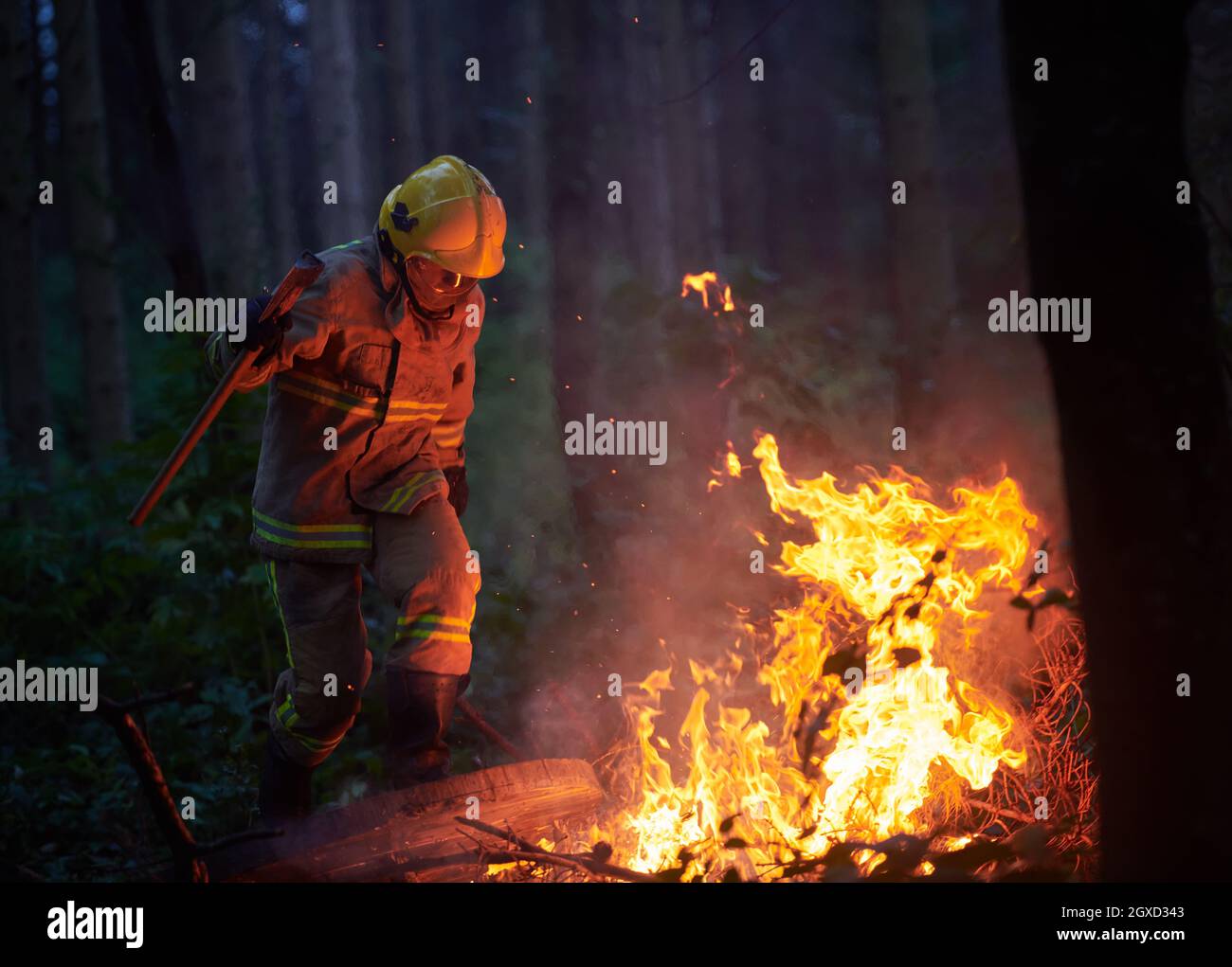 firefighter hero in action danger jumping over fire flame to rescue and ...