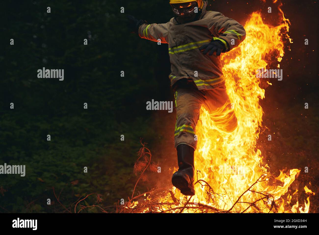 firefighter hero in action danger jumping over fire flame to rescue and ...