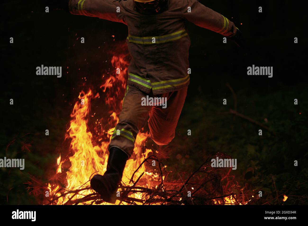 firefighter hero in action danger jumping over fire flame to rescue and ...