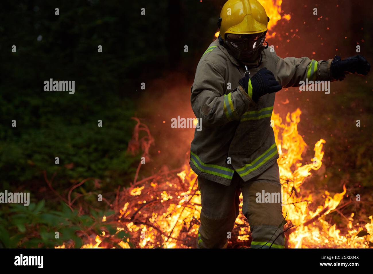 firefighter hero in action danger jumping over fire flame to rescue and ...