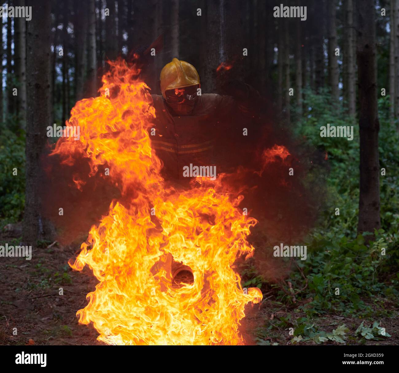 firefighter hero in action danger jumping over fire flame to rescue and ...