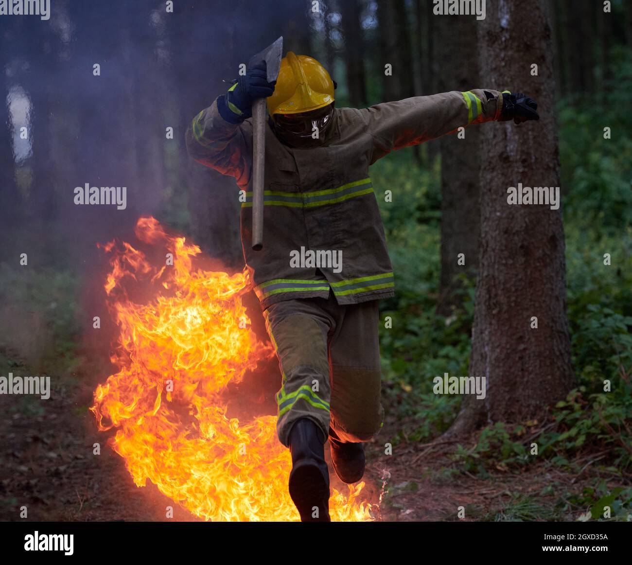 firefighter hero in action danger jumping over fire flame to rescue and ...