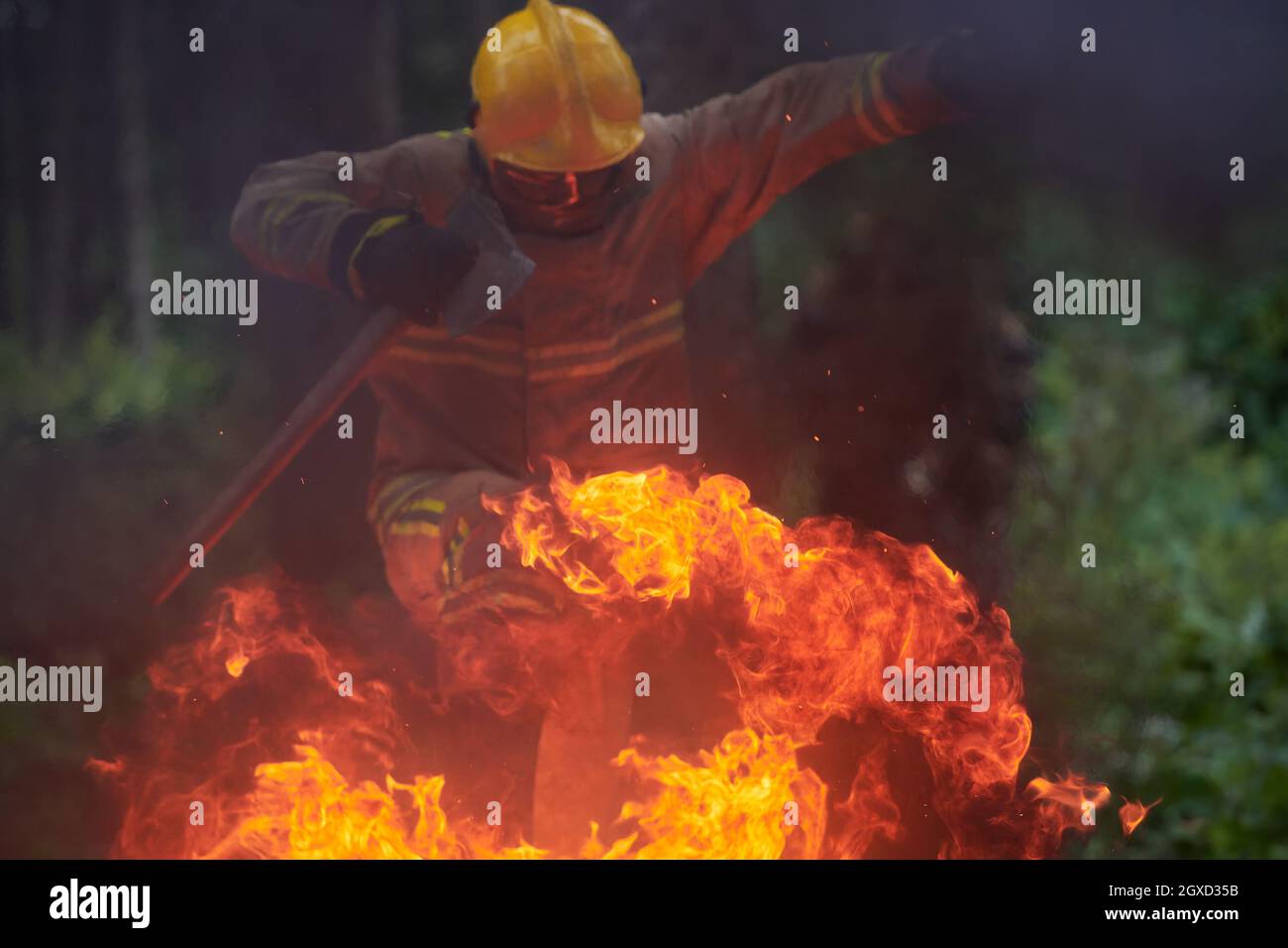 firefighter hero in action danger jumping over fire flame to rescue and ...