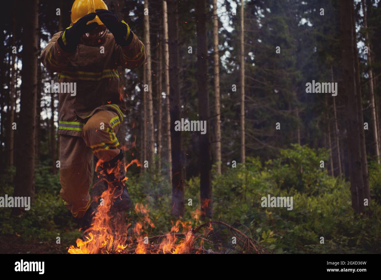 firefighter hero in action danger jumping over fire flame to rescue and ...