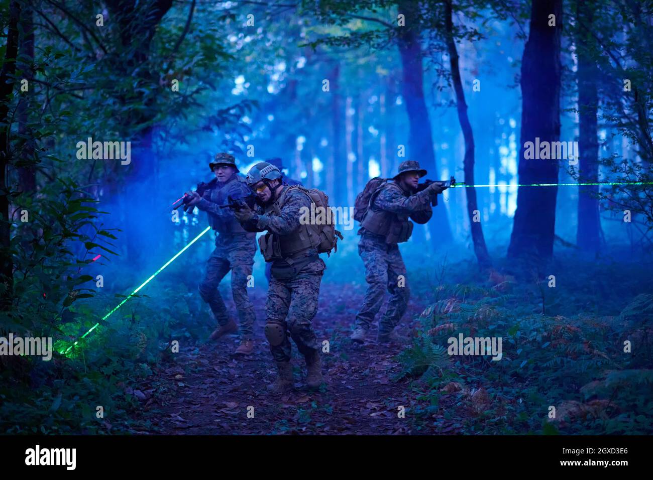 soldiers squad in action on night mission using laser sight beam lights ...