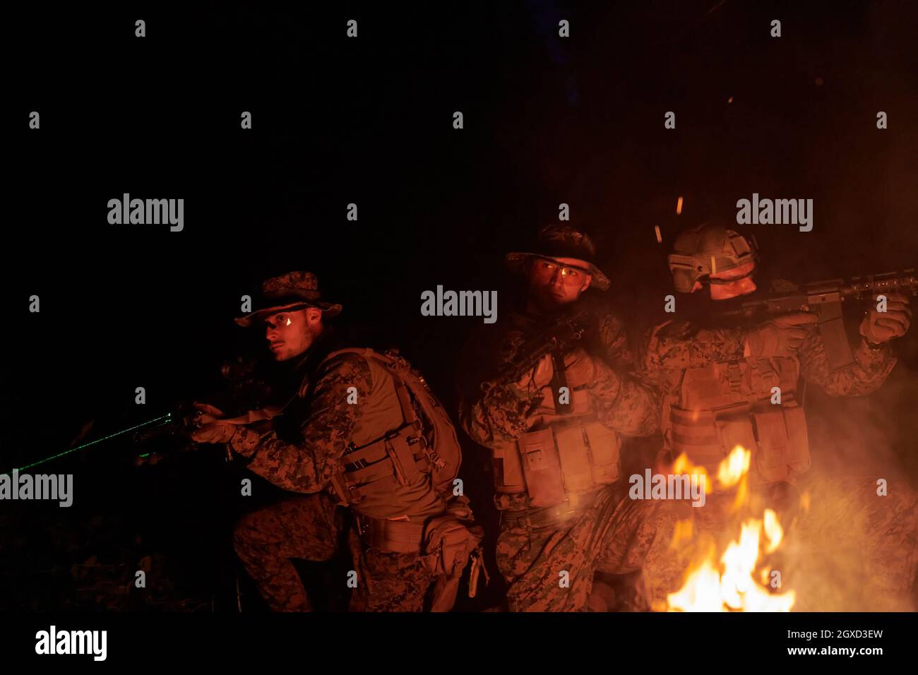 soldiers squad in action on night mission using laser sight beam lights ...
