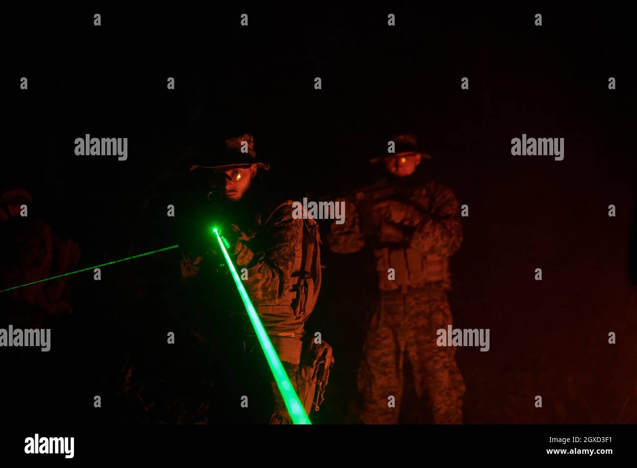 soldiers squad in action on night mission using laser sight beam lights ...