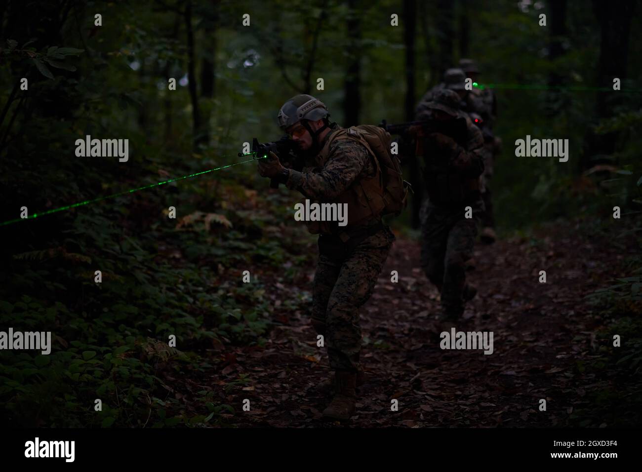 soldiers squad in action on night mission using laser sight beam lights ...