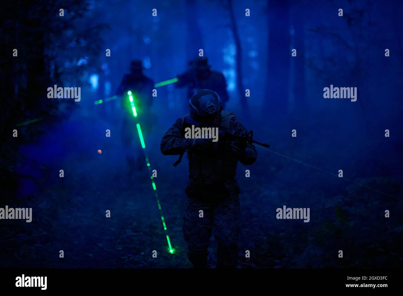 soldiers squad in action on night mission using laser sight beam lights ...