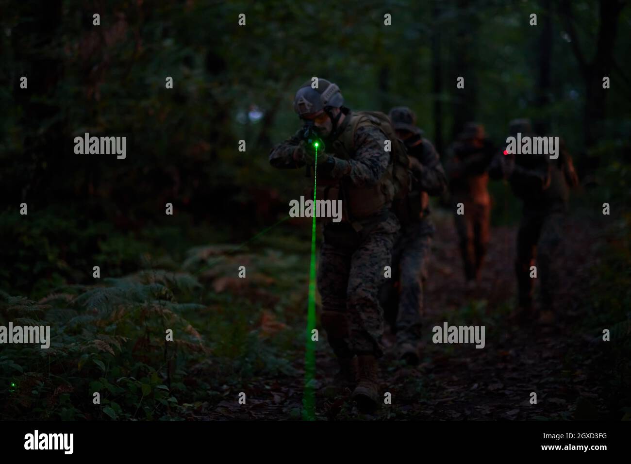 soldiers squad in action on night mission using laser sight beam lights ...