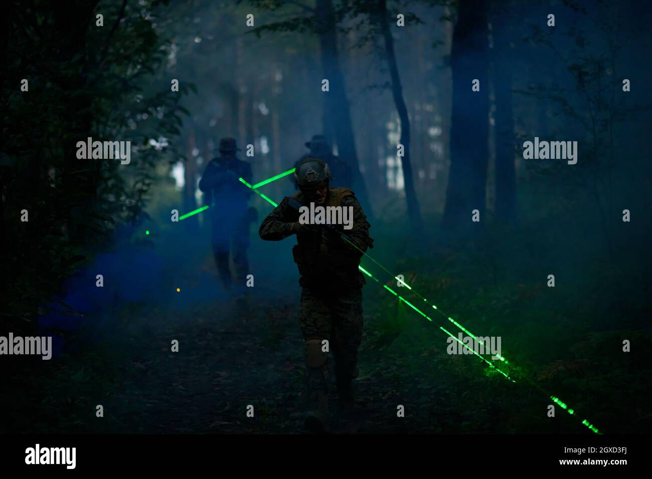 soldiers squad in action on night mission using laser sight beam lights ...