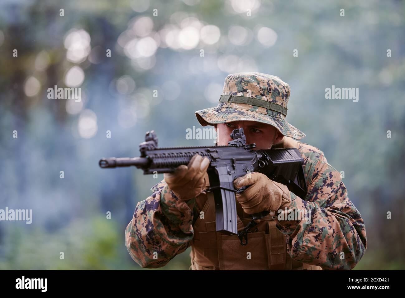 modern warfare soldier in action aiming at weapon laser sight optics in combat position while ...