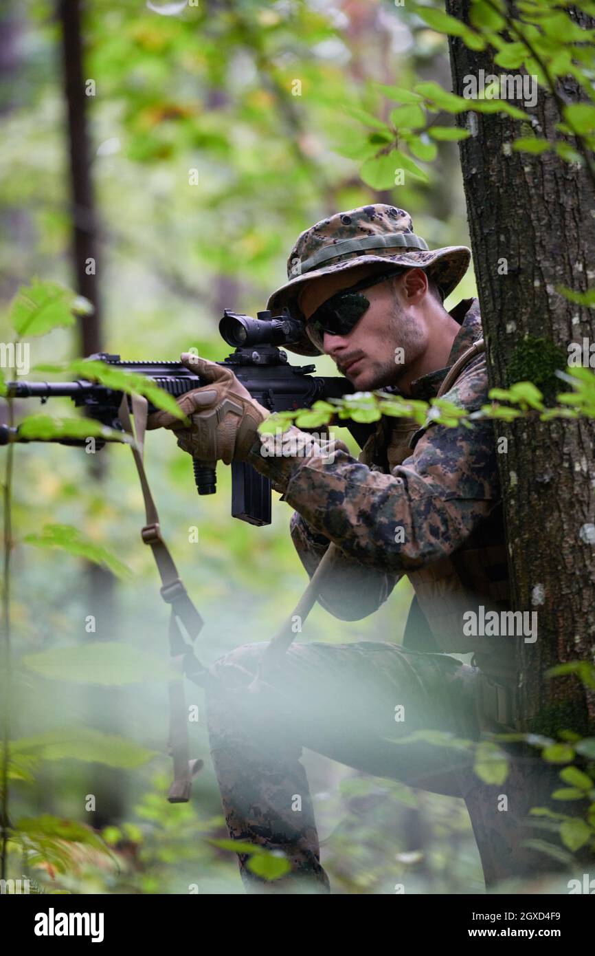 modern warfare soldier in action aiming at weapon laser sight optics in ...