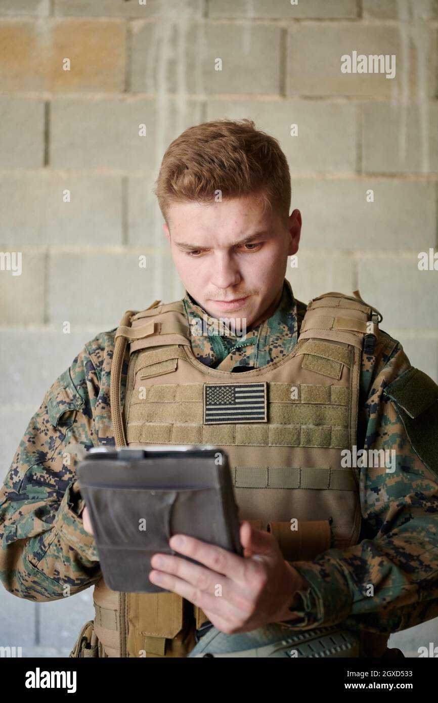 soldier using tablet computer against old brick wall Stock Photo - Alamy