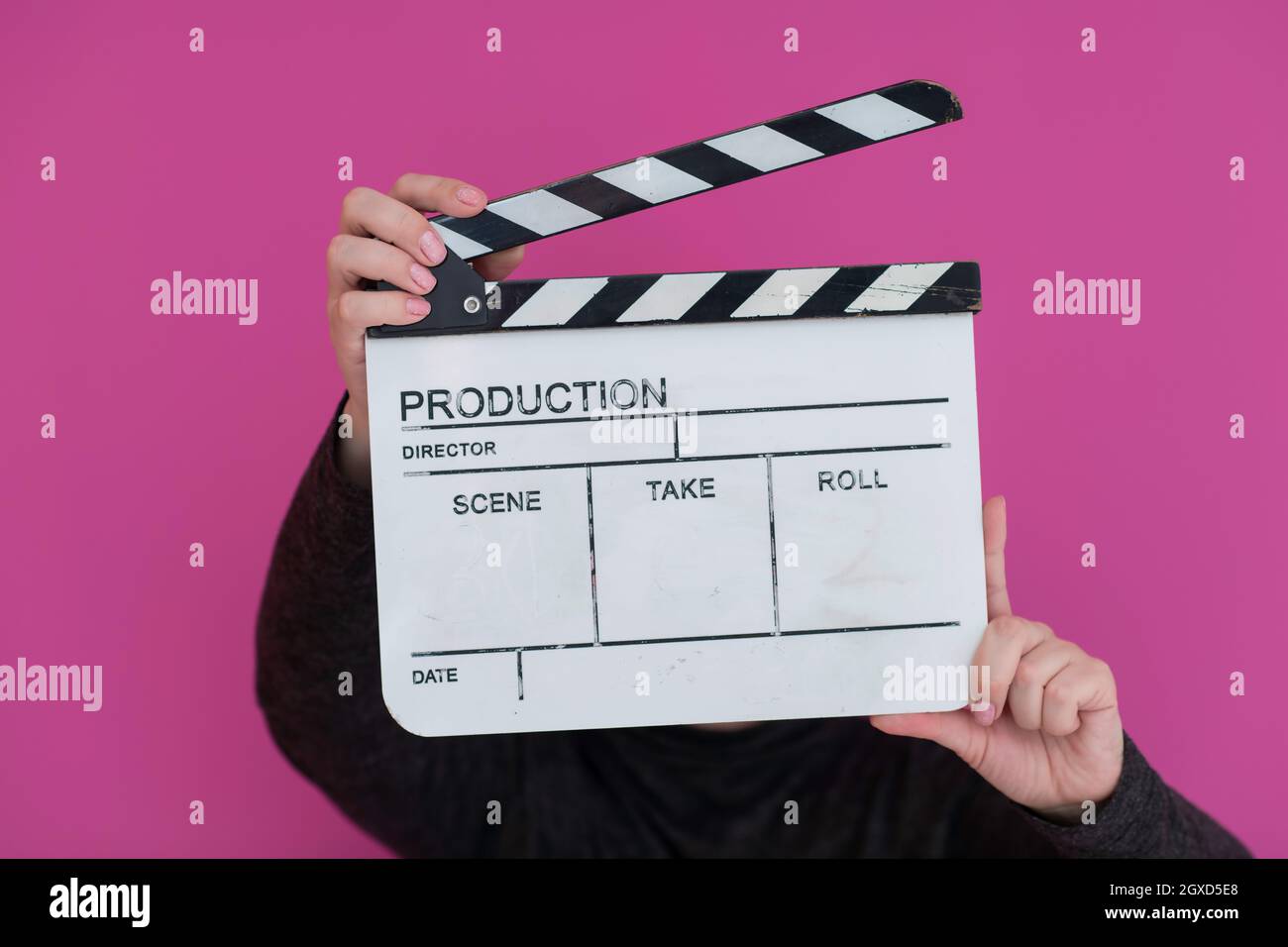redhead woman holding movie clapper isolated against pink background ...