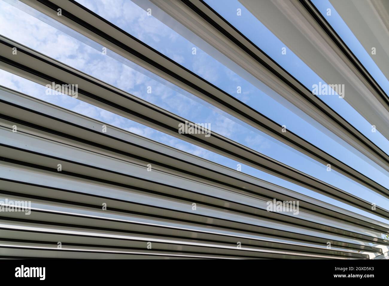 Low angle of ceiling of modern house with metal panels and glass ...