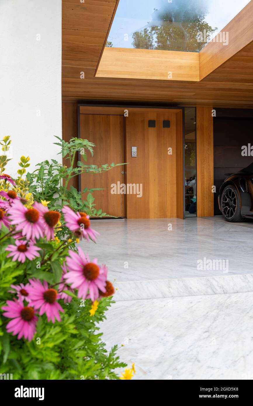 Luxury villa yard with blooming flowers and modern car parked in garage ...