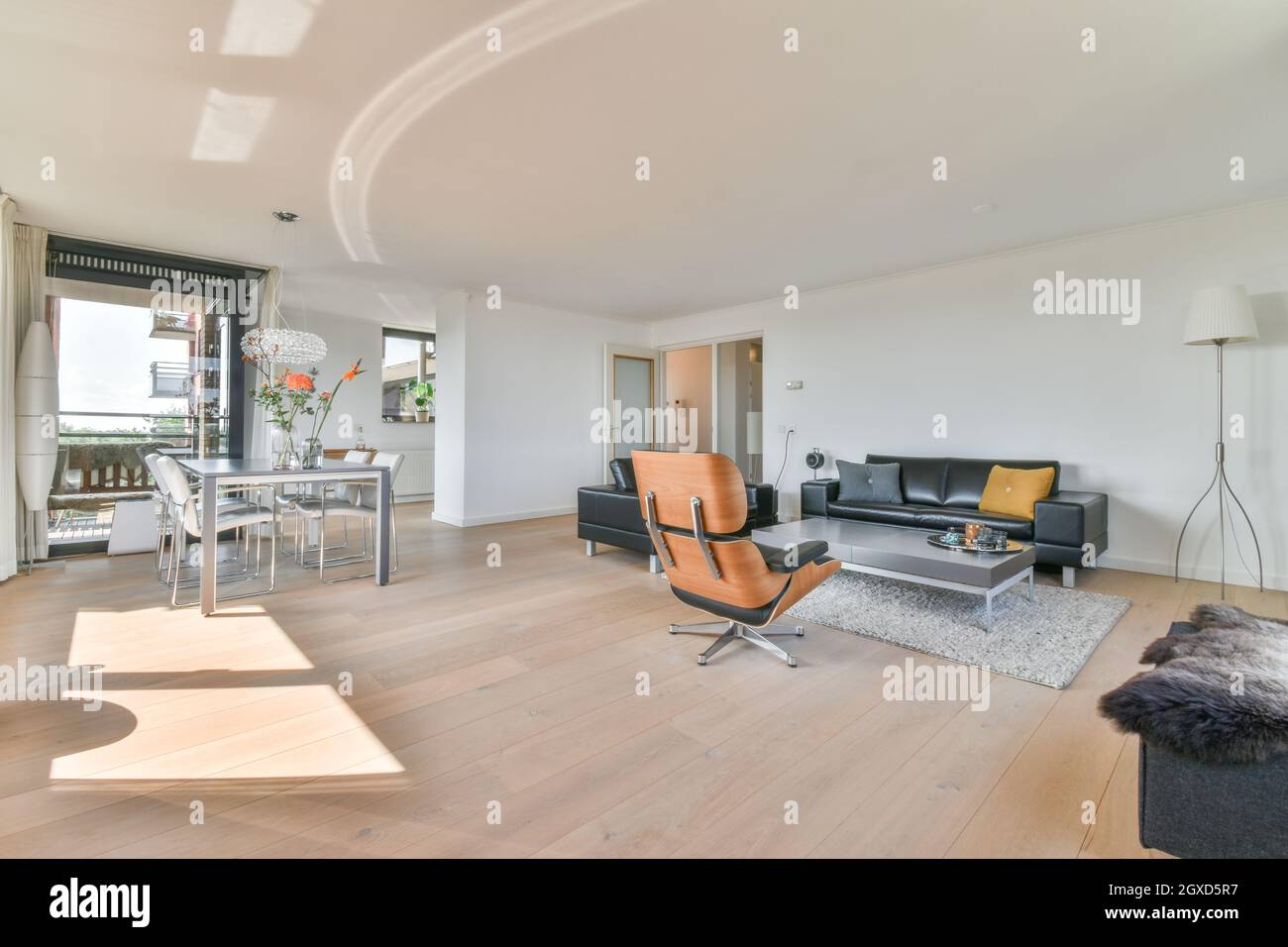 Contemporary dining room interior with table against sofas in house ...