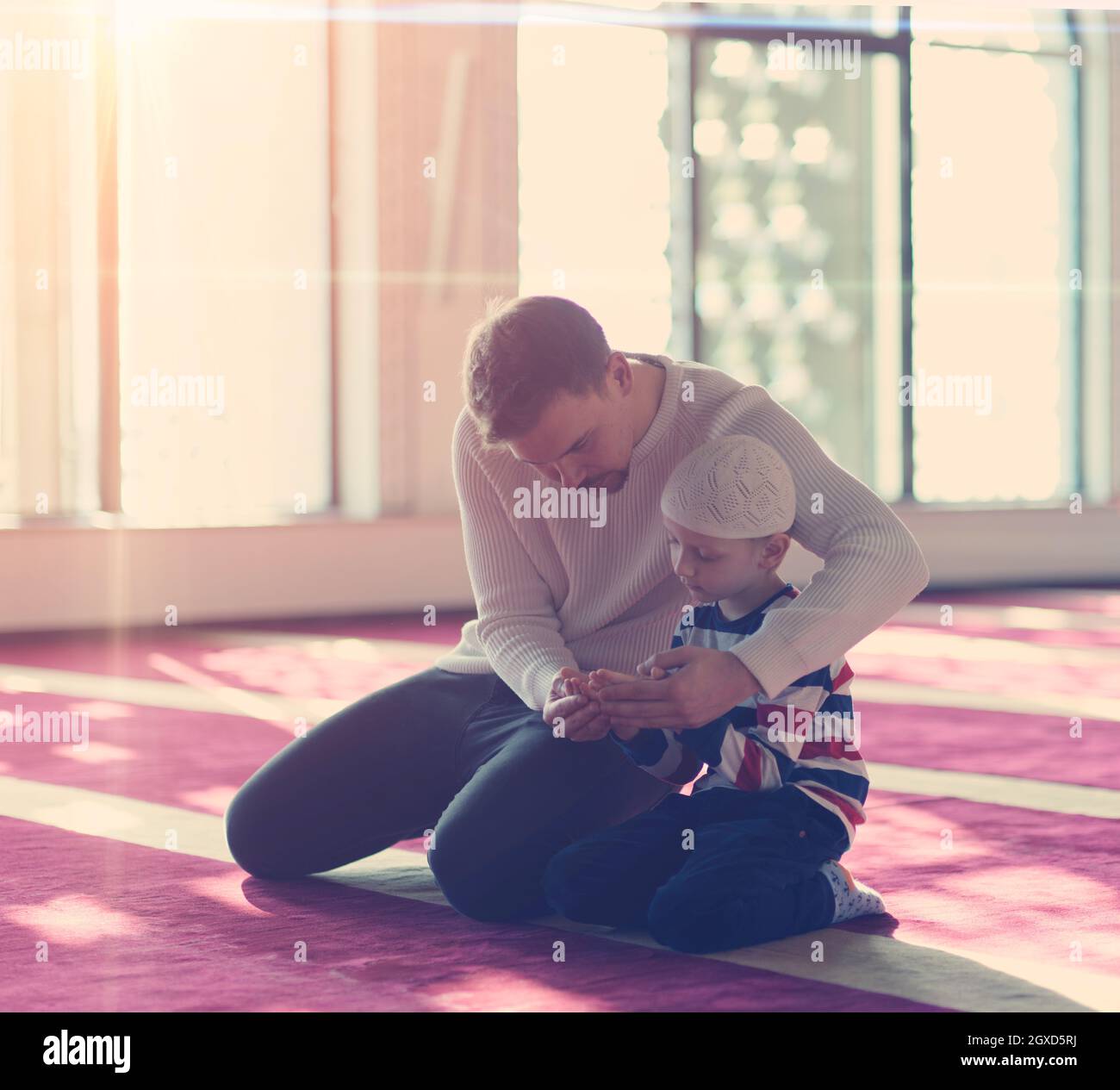 muslim prayer father and son in mosque praying and reading holly book ...