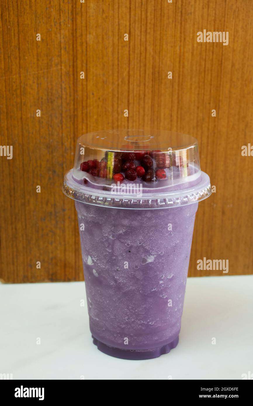 Blueberry fruits smoothie topping red berry served in plastic glass cup ...