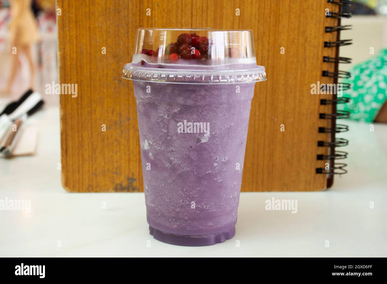 Blueberry fruits smoothie topping red berry served in plastic glass cup ...