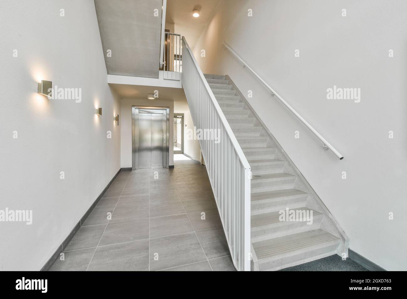 Modern interior of spacious hallway with staircase and lift with metal ...