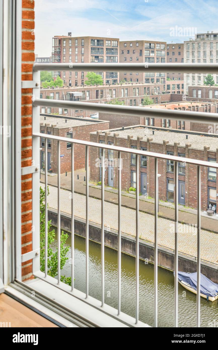 View through window of apartment on city street with river channel and ...