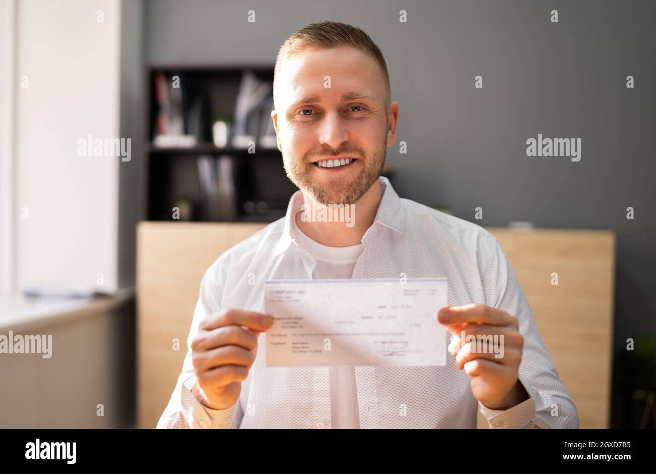 Holding Paycheck In Hand. Insurance And Payroll Check Stock Photo - Alamy