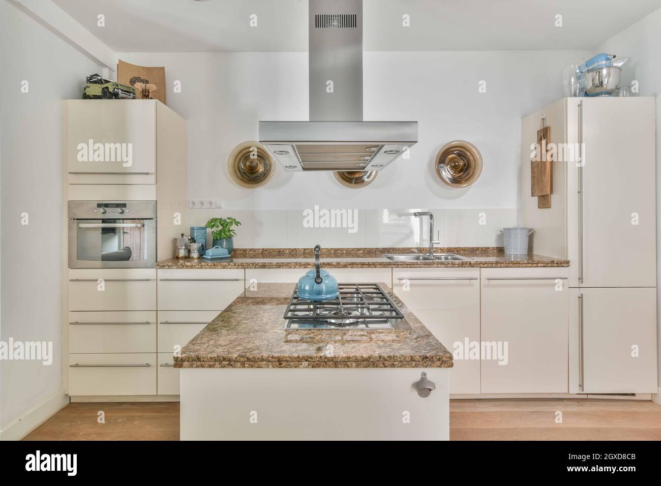 Kettle placed on stove under ventilation in spacious kitchen with light ...
