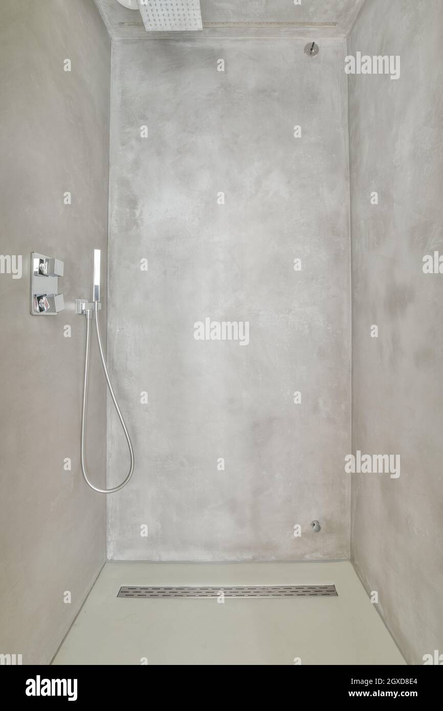 Empty clean shower cabin with gray concrete walls in modern bathroom in ...