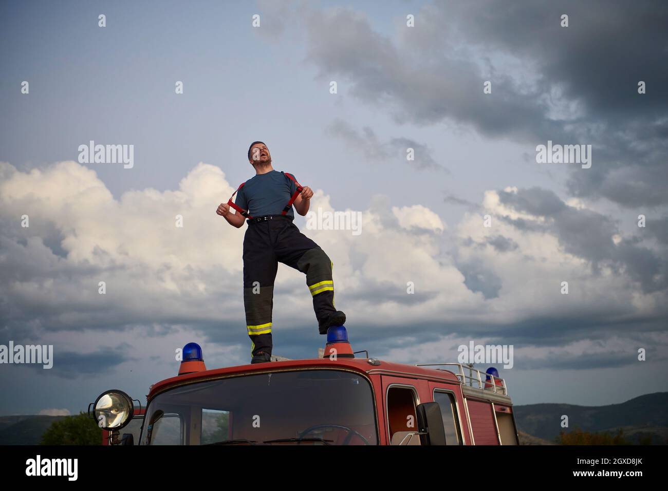 firefighter out of duty have funny while posing on top of fireman truck ...