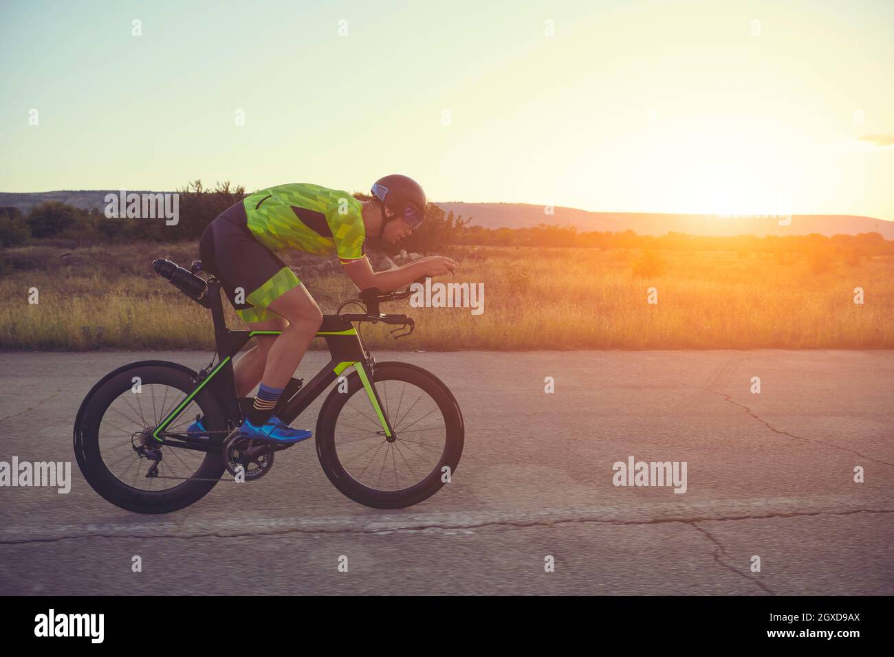 triathlon athlete riding professional racing bike on morning workout ...