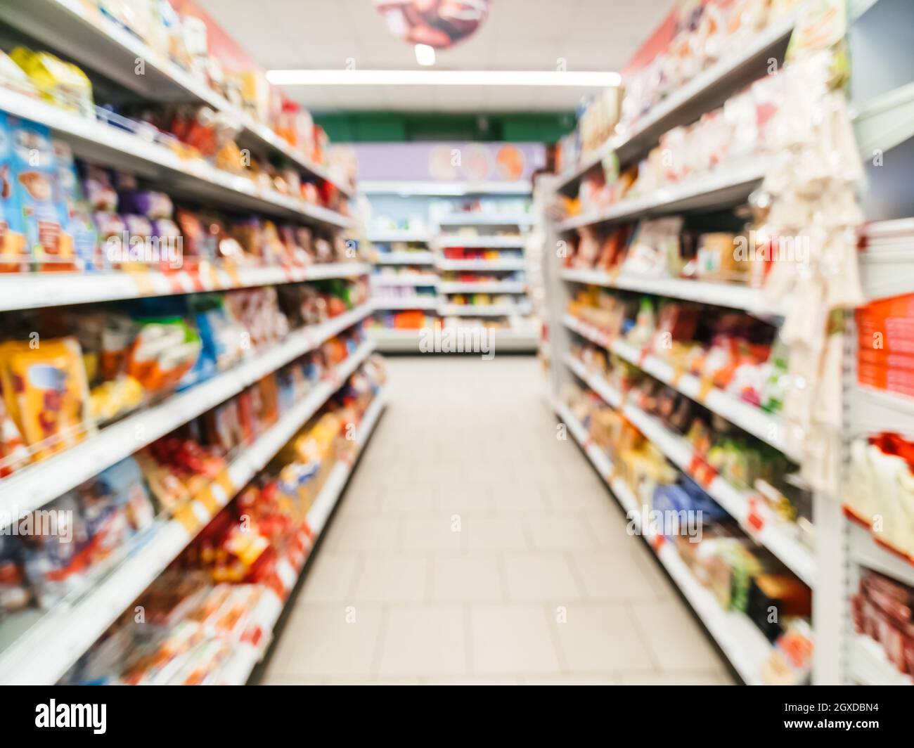 Abstract blurred supermarket aisle with colorful shelves and ...