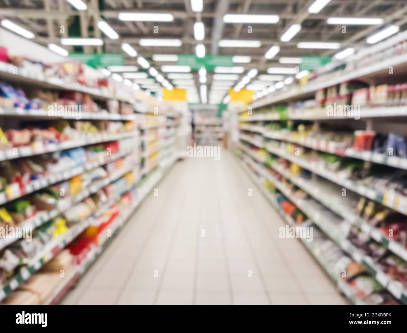 Blurred supermarket aisle with colorful shelves of merchandise ...