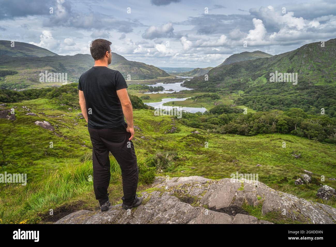 Middle age man standing on a rock and admiring beautiful Ladies View ...
