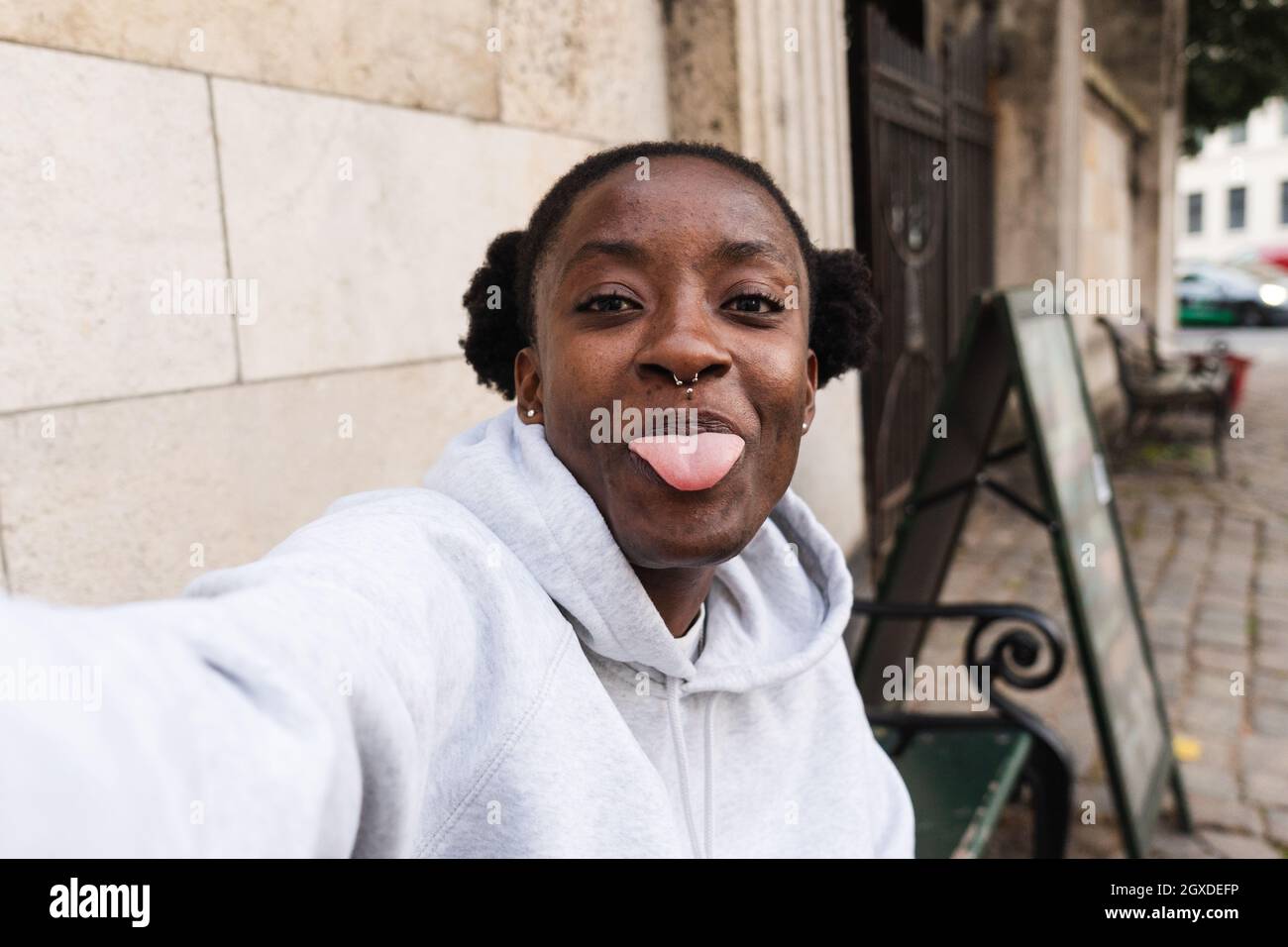 Playful African American female with piercing taking self portrait with ...