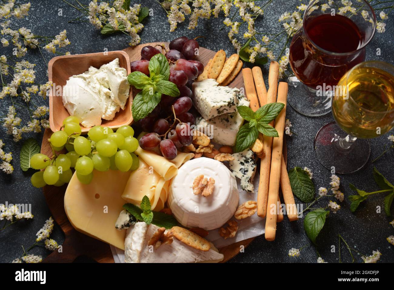 Cheese platter with assorted cheeses, grapes, nuts and snacks . Italian ...