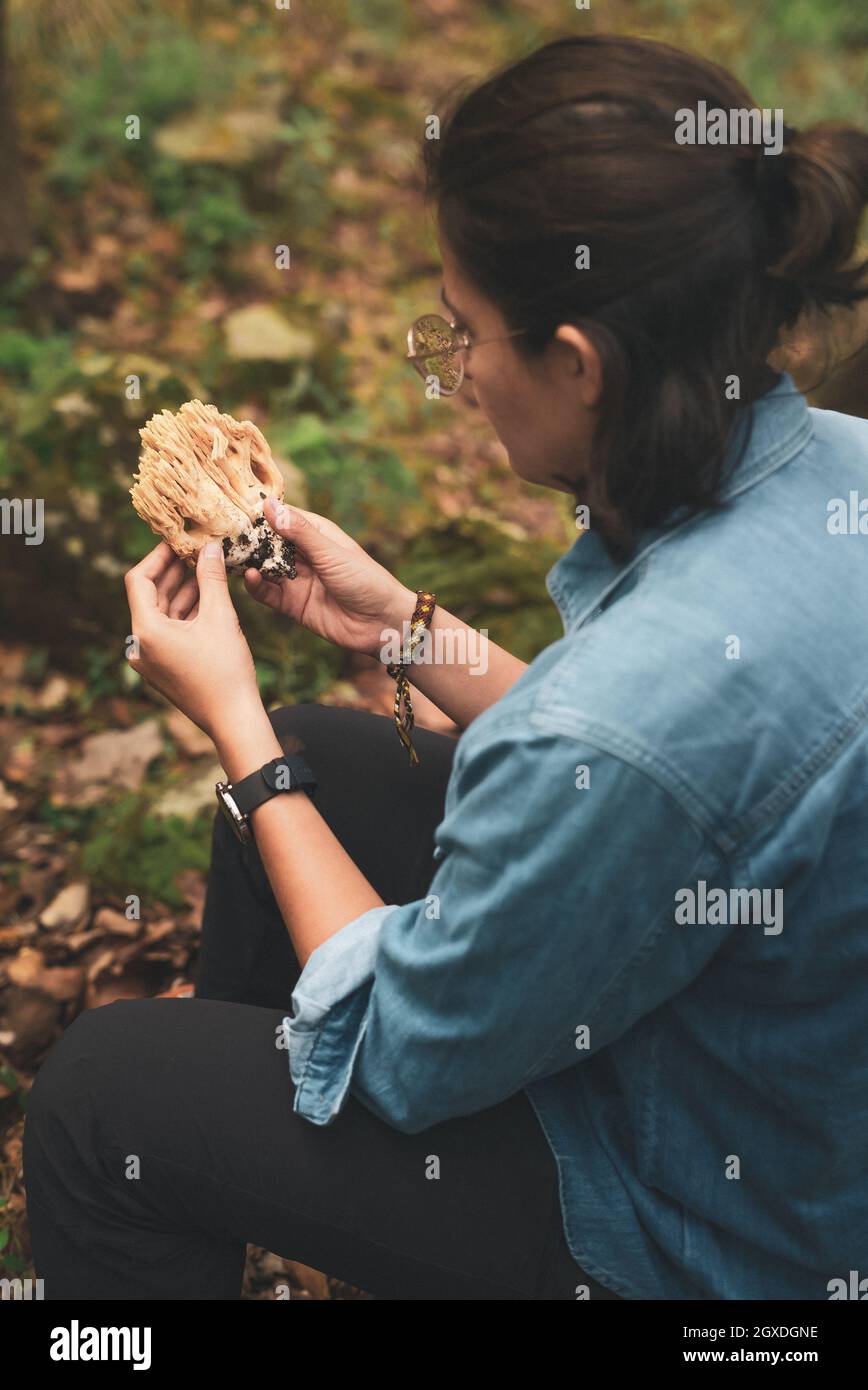 From above cropped unrecognizable female mycologist taking off dirt ...