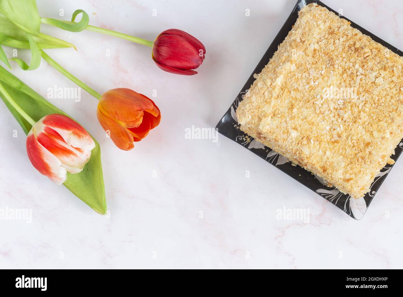 Three red tulips and a delicious cake on the festive table Stock Photo ...