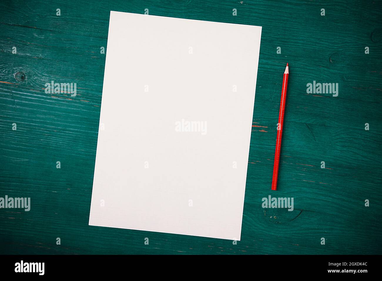 A blank white sheet and pencil for drawing on a wooden background with ...