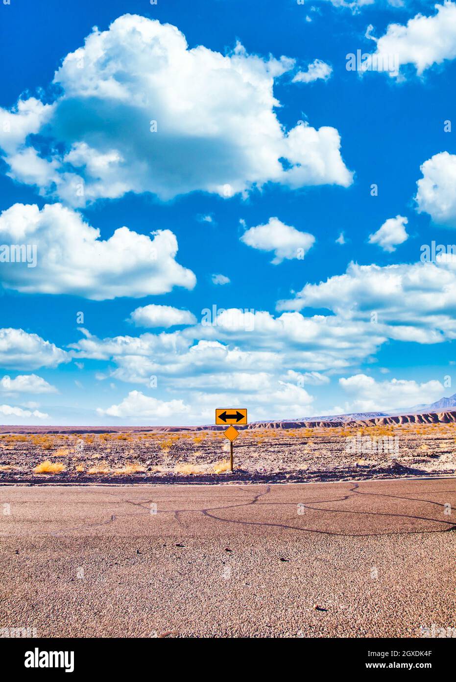 Directional sign in the desert with scenic blue sky and wide horizon ...