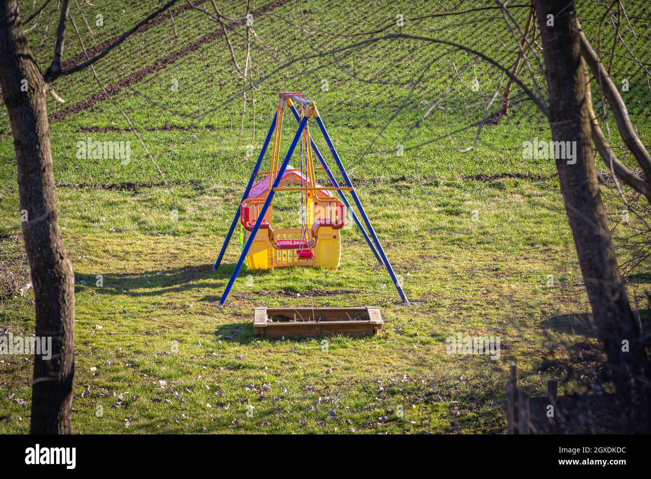colorful empty playground with sand pit on a meadow Stock Photo - Alamy
