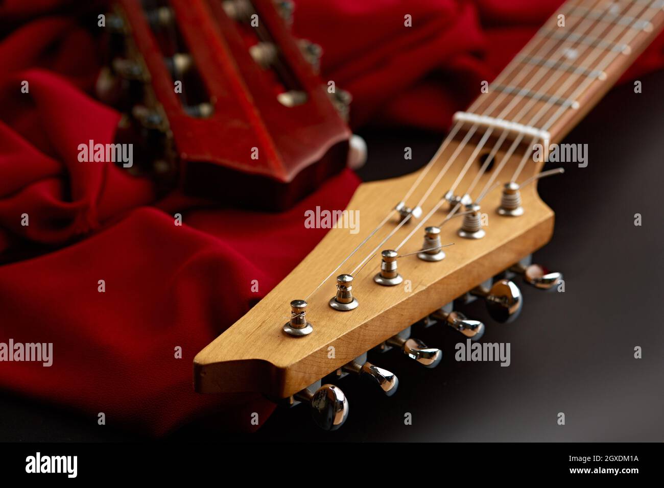 Modern electric and classical acoustic guitar heads closeup, black ...