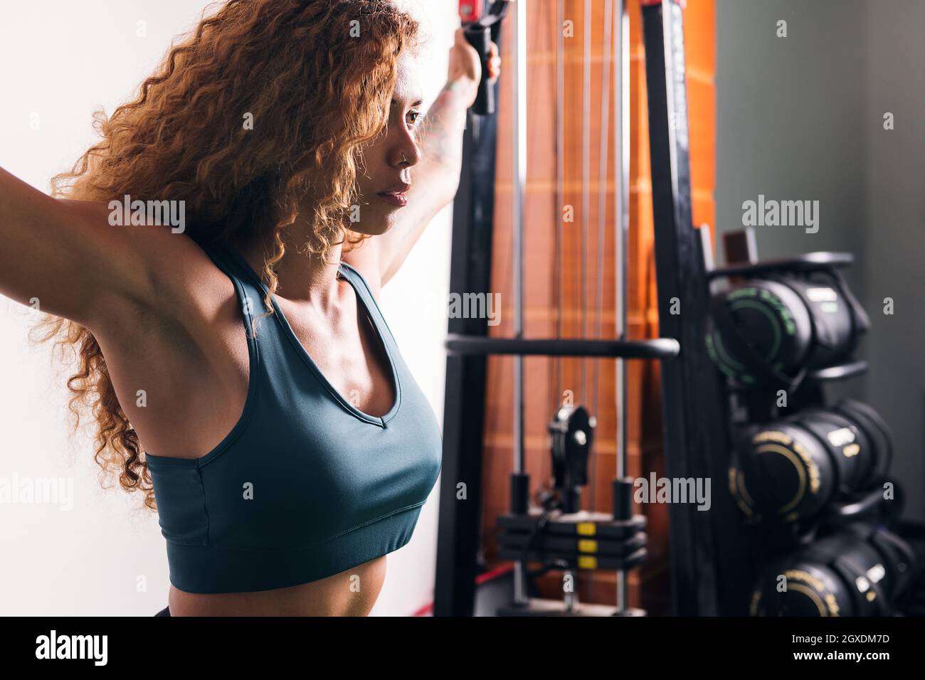 Strong sportsWoman with king curly hair in activewear doing exercises ...