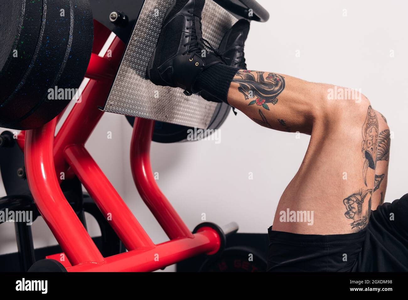 Side view of crop muscular sportsman with tattoos doing exercises on ...
